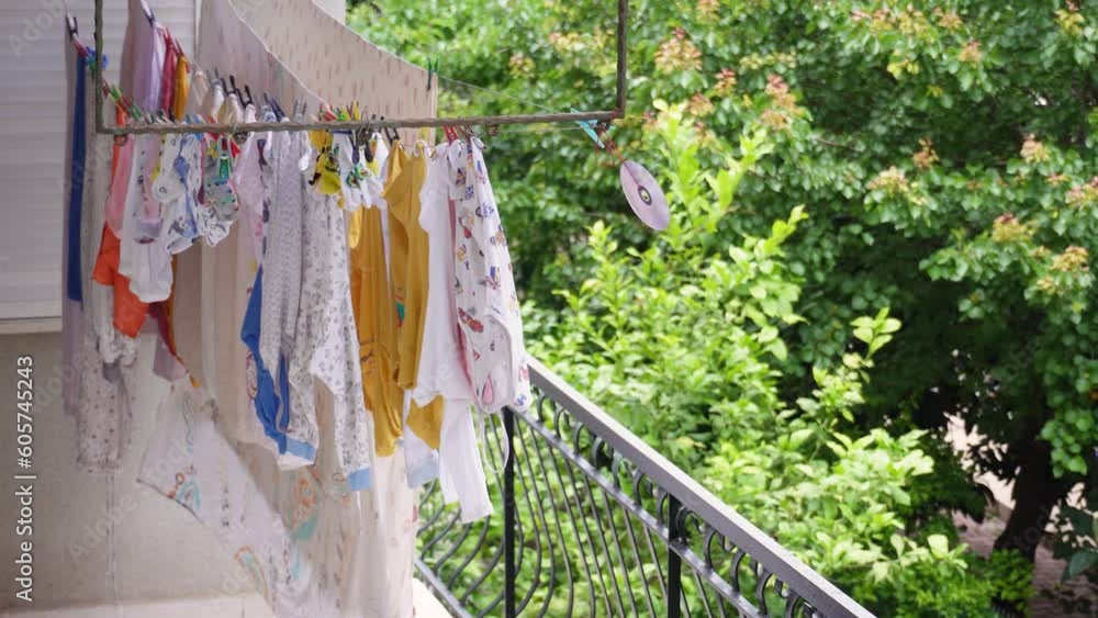 Colorful laundry dries on balcony in summer breeze. Simple and ...