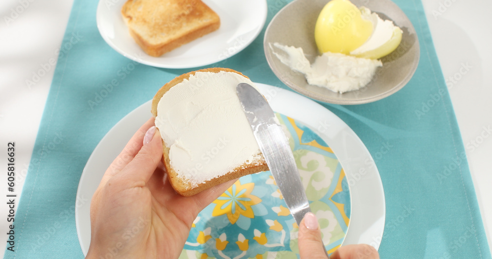 spreading cream cheese on toast with knife. making a sandwich. Balkan ...
