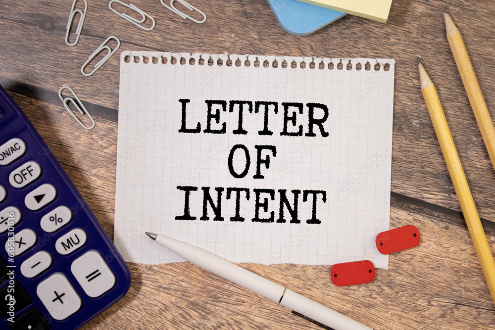 LETTER OF INTENT text on a paper clipboard with magnifier and keyboard ...