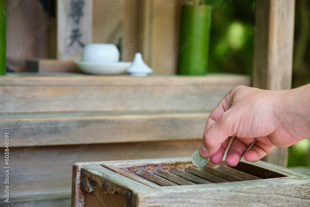 Hand making a offering in wooden offering box or Saisen Box, in ...