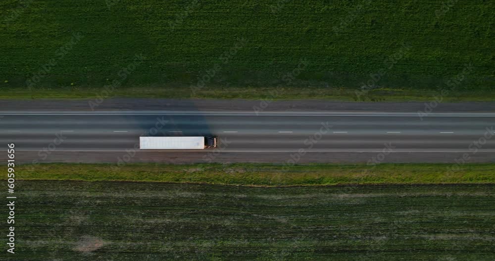 A truck with a semi-trailer is driving along a straight highway, aerial ...
