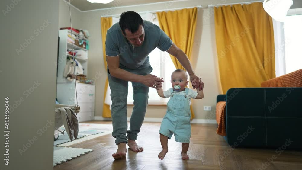 Baby first steps.Toddler at home takes funny first steps.Dad teaches ...