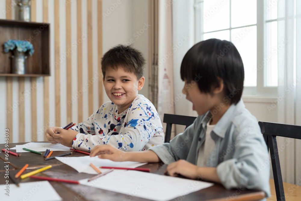 Happy two boy using colour pencil drawing on paper in the classroom at ...