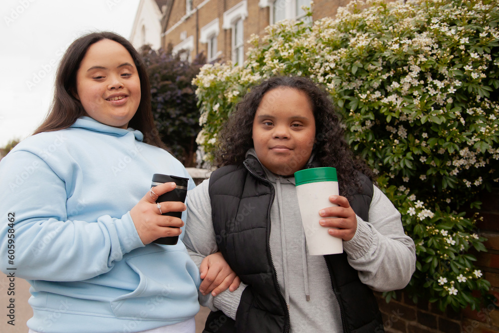 Two happy plus-sized women with Down Syndrome holding reusable coffee ...