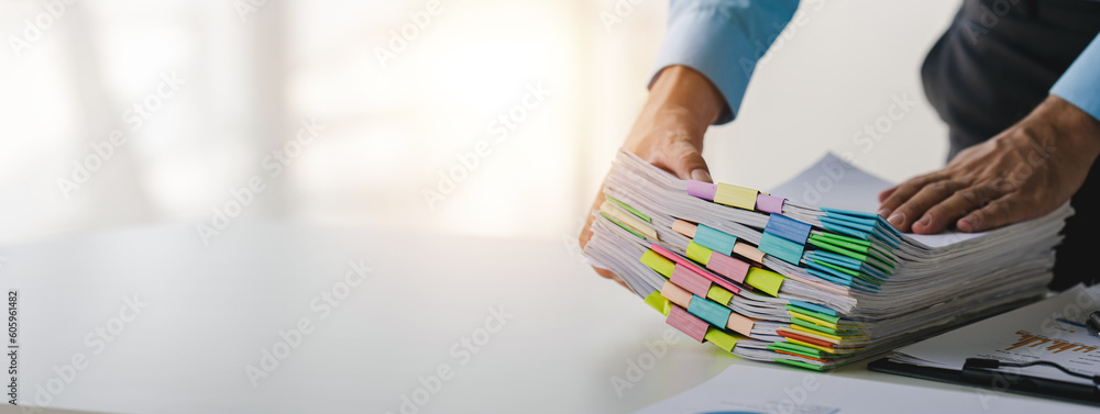 Businessman working on stacks of documents to search for information ...