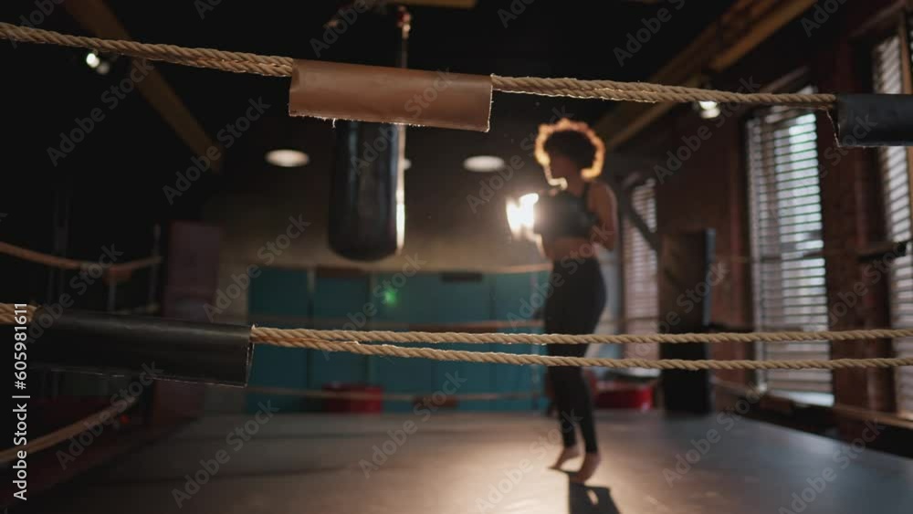Afro american woman boxer with curly hair boxing in gym on boxing ring ...