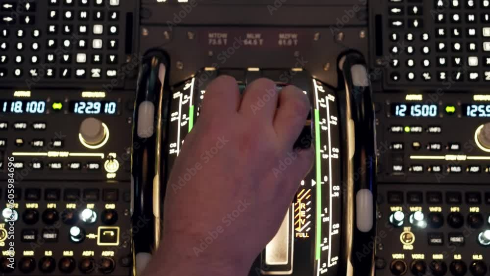 Pilot pressing on taking off button with illuminated dashboard inside a ...