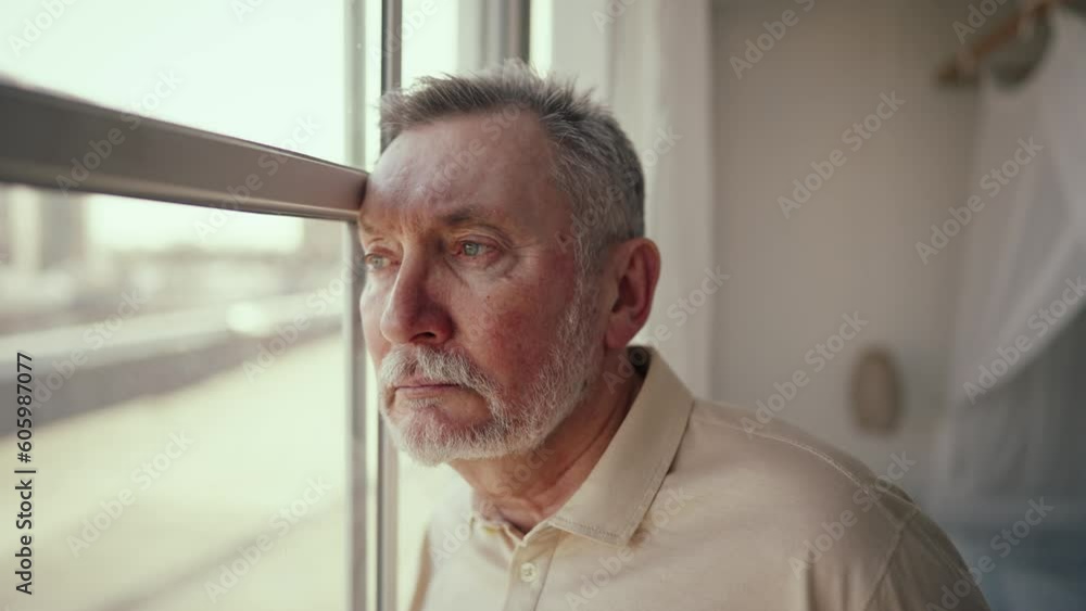 Close up sad elderly man face looking out the window, yearning about ...