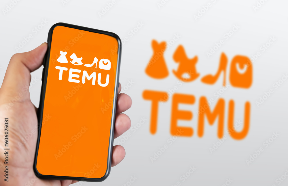 Hand holding a phone with Temu logo displayed on the screen Stock Photo ...