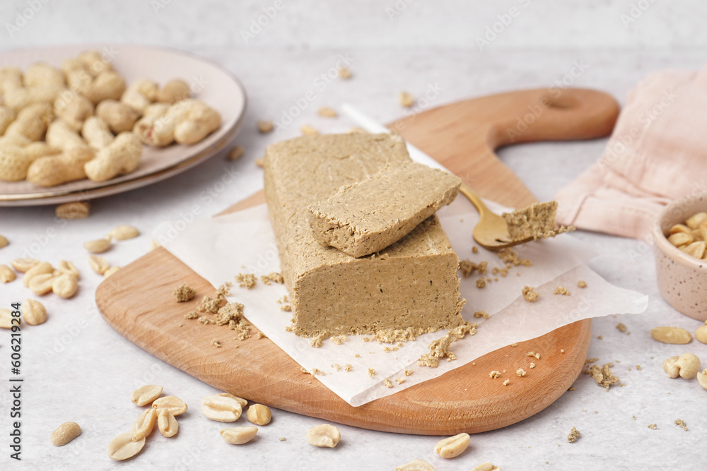 Board with tasty halva and peanuts on white background Stock Photo ...