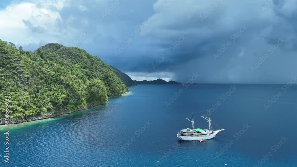Rain falls on the sea surrounding islands in Raja Ampat's dramatic ...