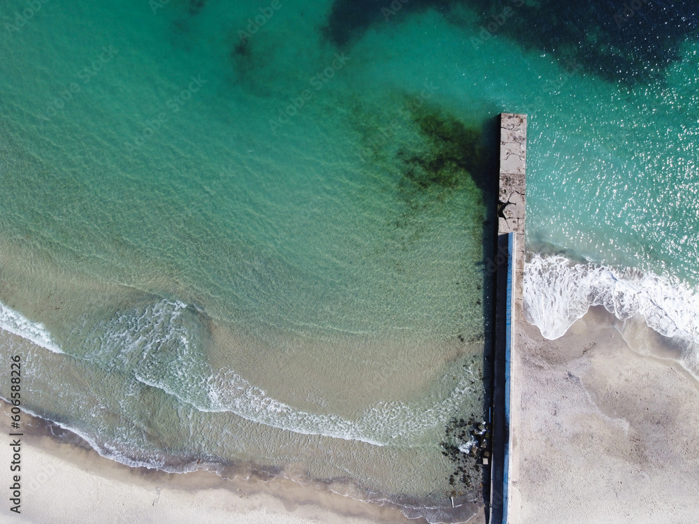 Aerial top down view of old concrete pier or breakwater with emerald ...