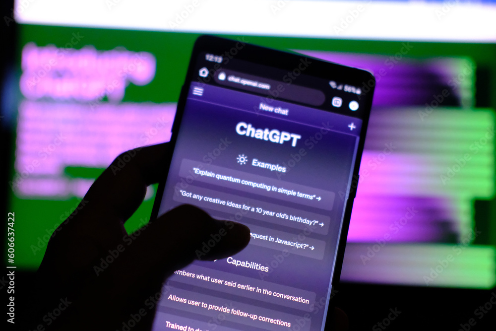 ChatGPT chat bot screen seen on smartphone and blurred laptop display with Chat GPT login screen ...