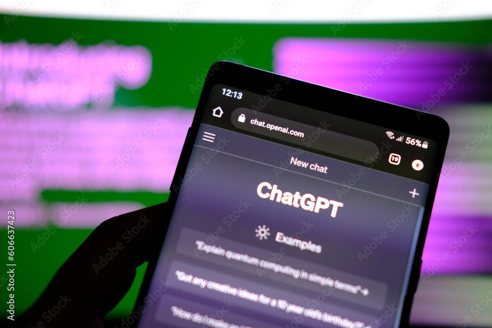 ChatGPT chat bot screen seen on smartphone and blurred laptop display with Chat GPT login screen ...