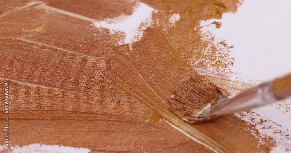 drawing lines with gold paint on canvas with an artistic brush, using ...