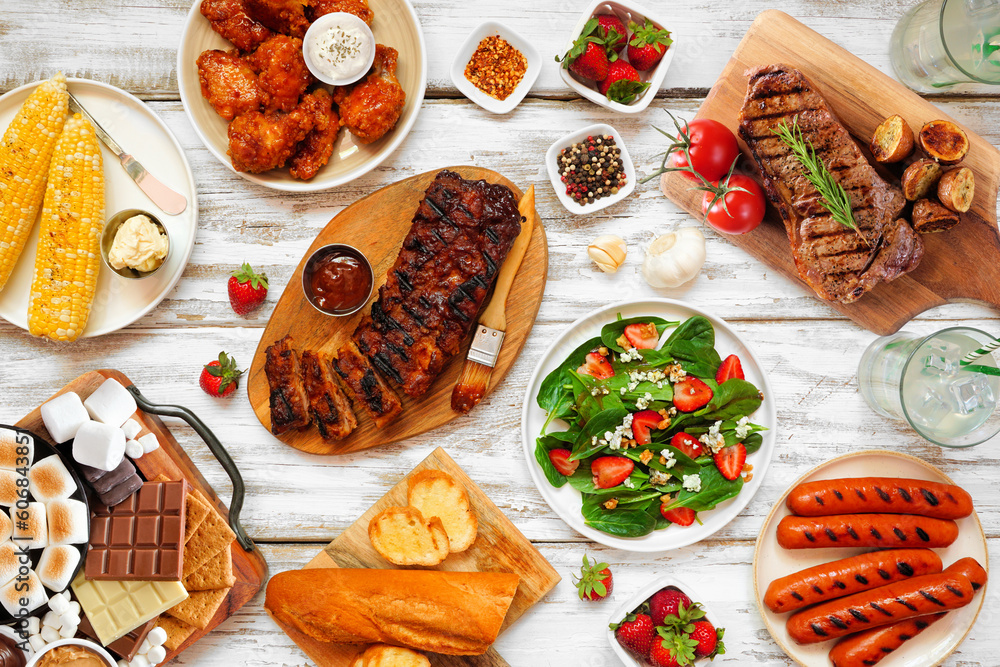 Summer BBQ food table scene over a white wood background. Variety of ...