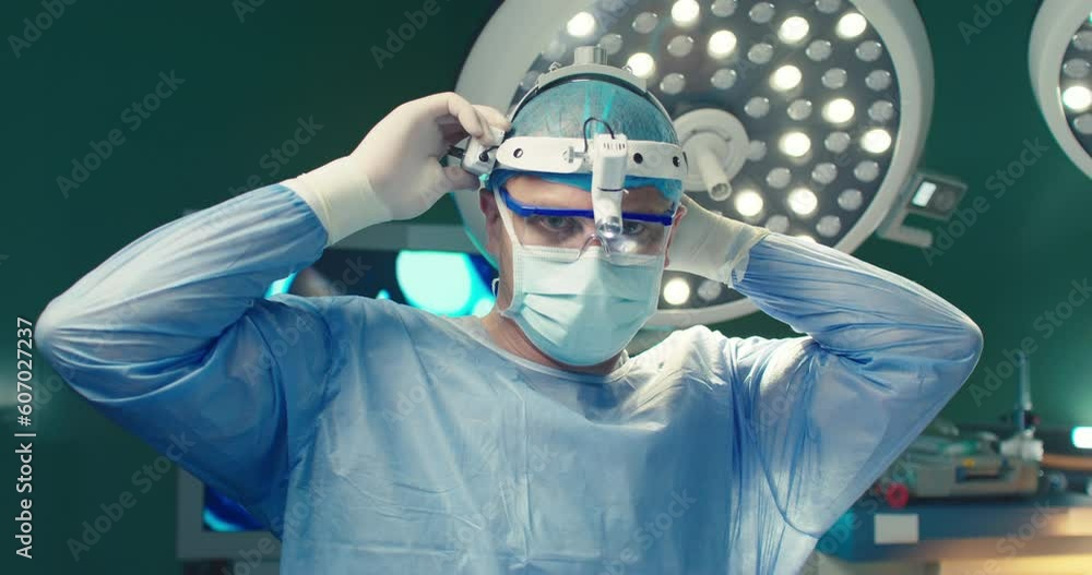 Professional surgeon dress up magnifying glass during medical surgery ...