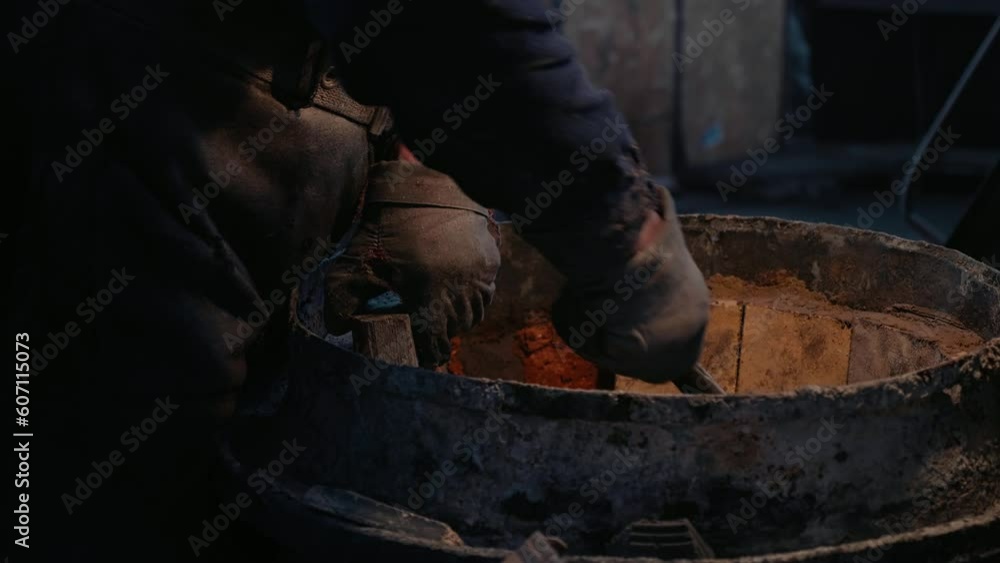 Close up ladle matrix being filled by man in metallurgucal workshop ...