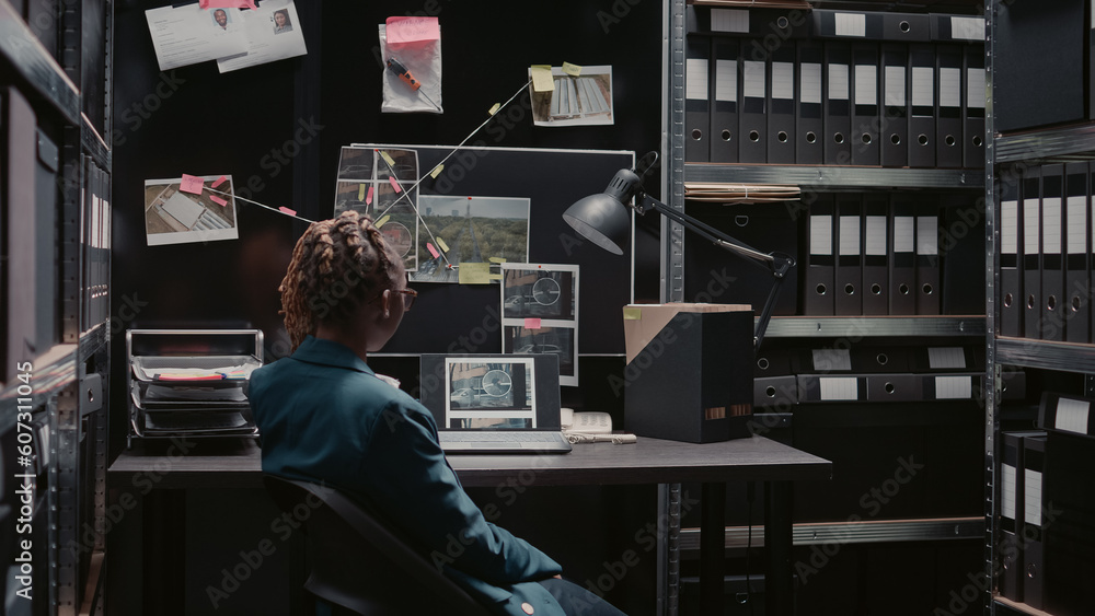 African american police investigator reading case file in incident room ...
