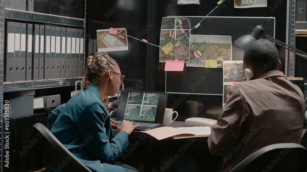 Team of detectives analyzing surveillance records and reading case file ...