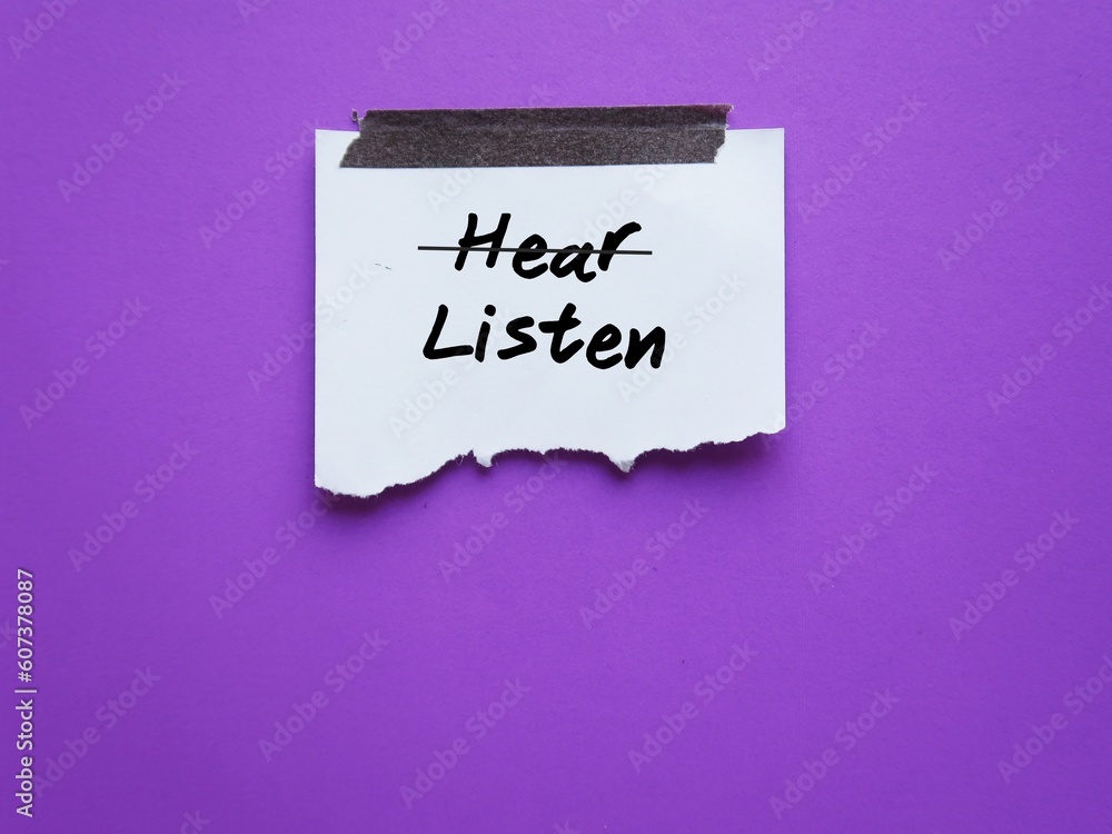 Stick note on purple background with handwritten text HEAR crossed off ...