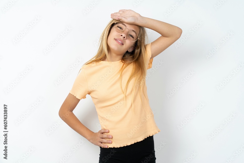 beautiful caucasian teen girl wearing orange T-shirt over white wall ...