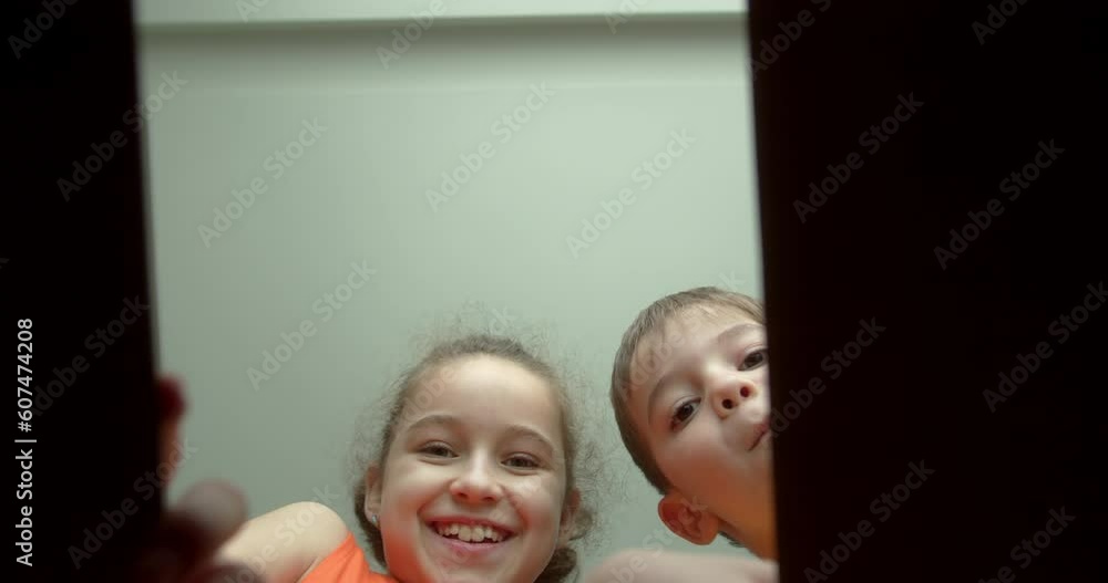 Children pull their hands into the box. Happy children, overjoyed at ...