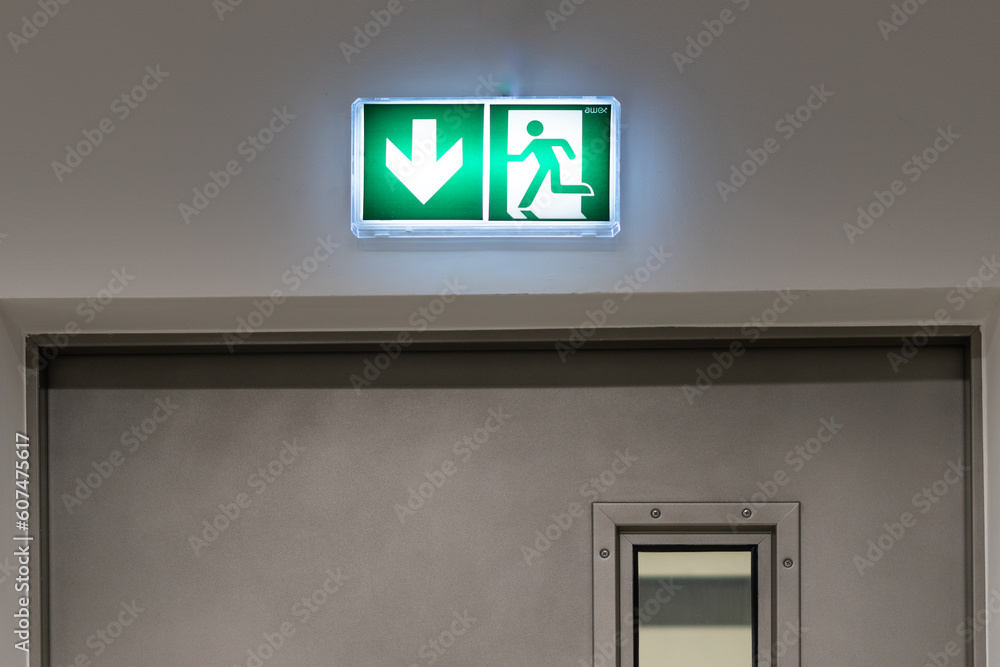 Foto de Emergency exit sign in an office building. Underground garage ...