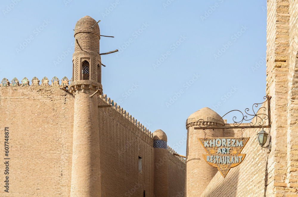 Narrow street between high walls with towers in the classic Central ...