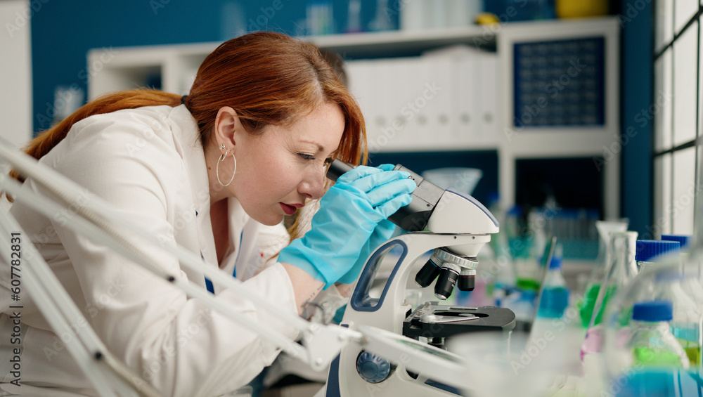 Man and woman wearing sciencist uniform using microscope at laboratory ...