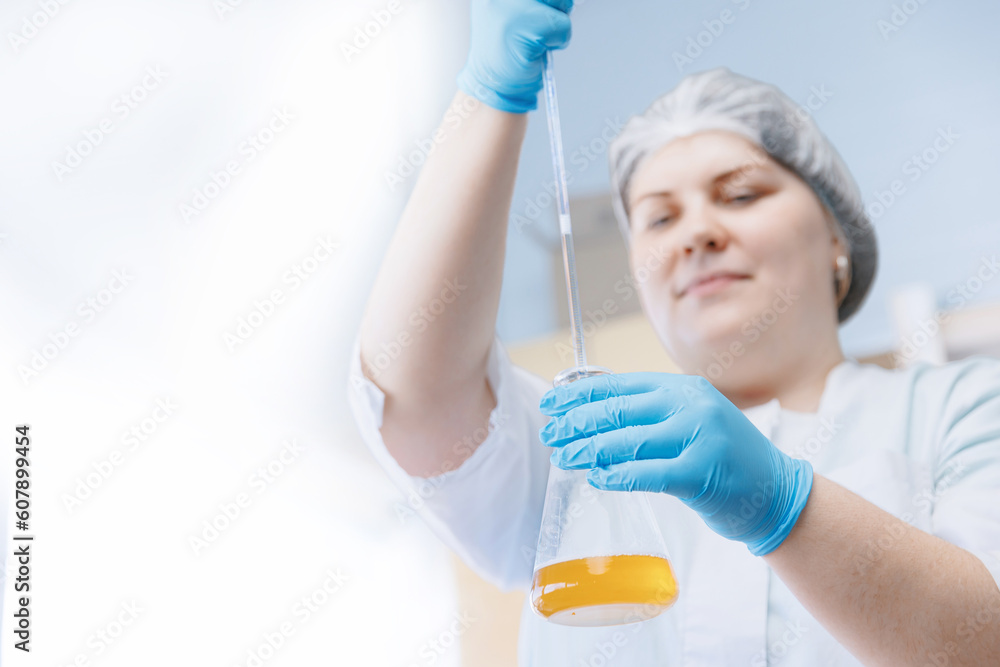 Foto de Woman laboratory assistant inspecting production beer, analysis ...