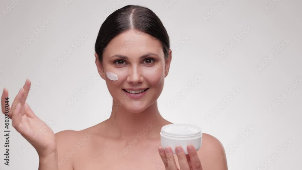 Female beauty procedures. Lady holding a container of cream applying ...