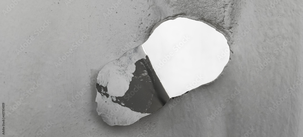 Hole with torn edges in iron. Ragged white pry in rusty metal sheet ...