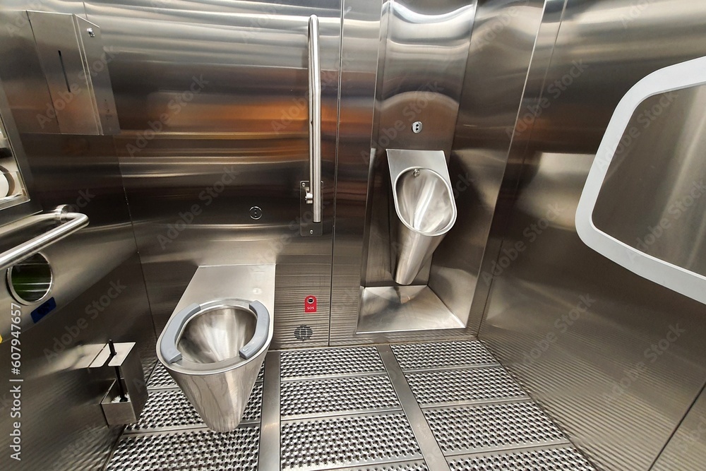 Sanitary metal urinal, toilet bowl in public bathroom with hygienic ...