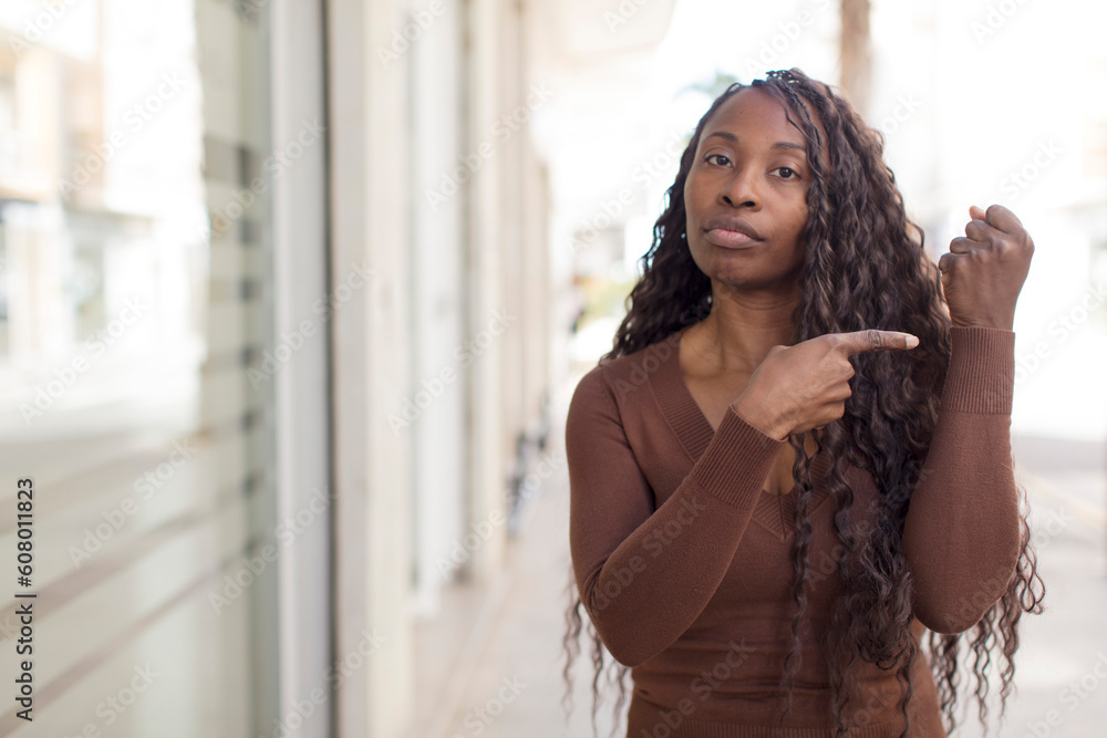 afro pretty black woman looking impatient and angry, pointing at watch ...