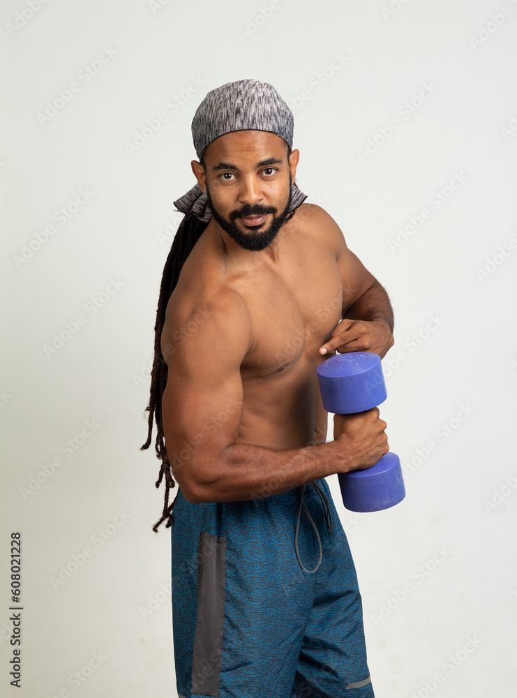 Muscular latin guy with dreadlocks and beard showing his arm holding a ...