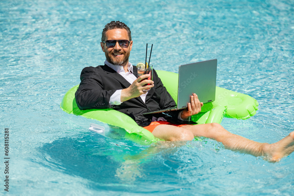 Crazy summer. Business drink summer cocktail and using laptop in suit ...