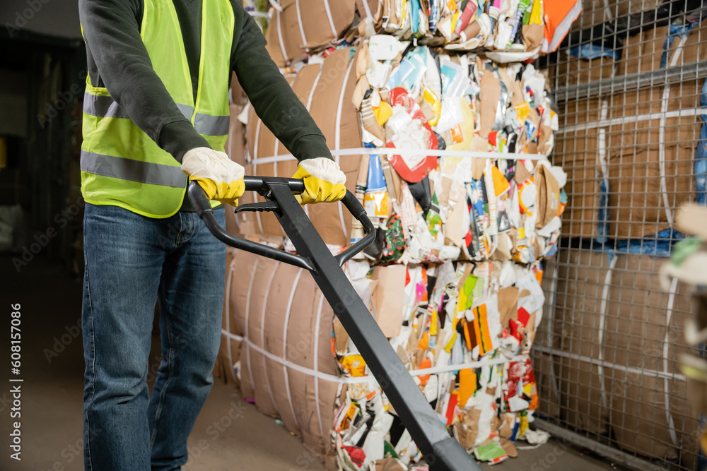 Cropped view of male sorter in protective gloves and vest using hand ...