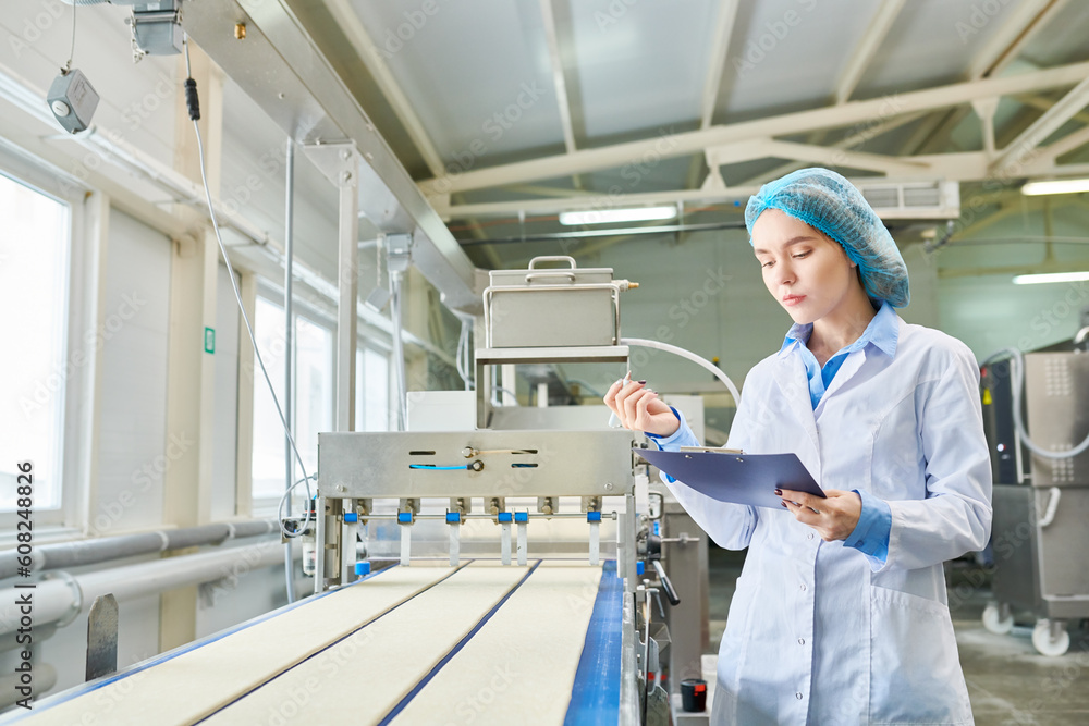 Concentrated beautiful young female food manufacturing engineer in ...