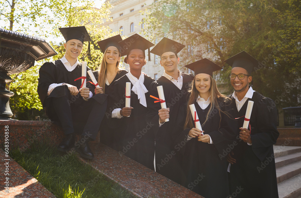 Happy college graduates standing in row with diplomas. Smiling graduate ...