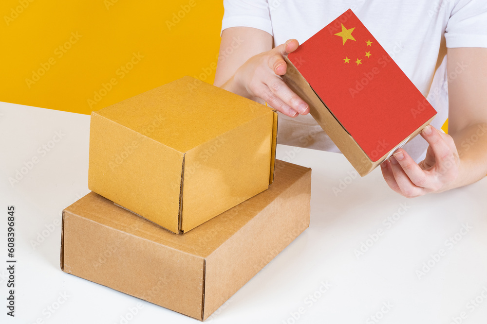 Foto de Box with China flag. Hands of Chinese entrepreneur. Cardboard ...