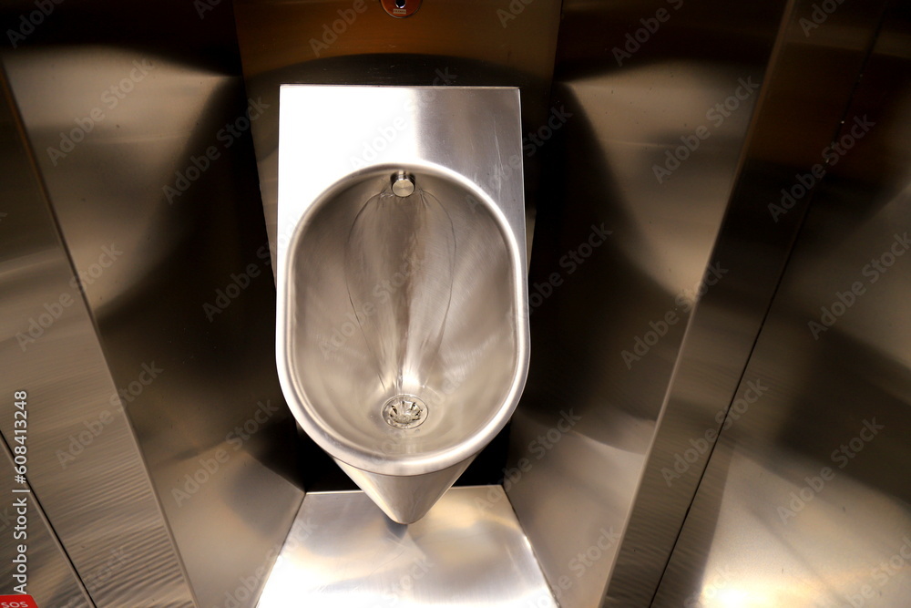 Sanitary metal urinal, toilet bowl in public bathroom with hygienic ...