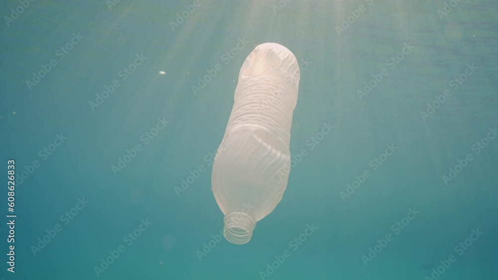 White plastic bottle drift under surface of water in sunrays. Plastic ...