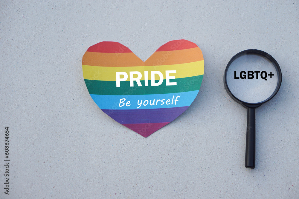 Rainbow paper heart shape with word PRIDE Be yourself and magnifying ...