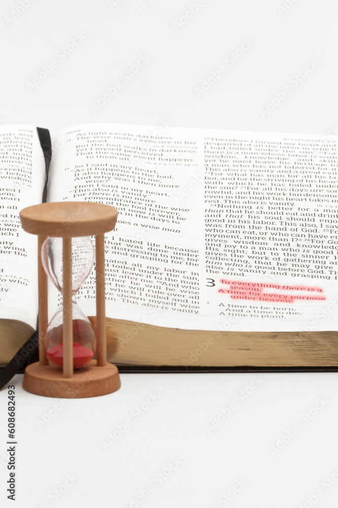 Hourglass and open Bible on the Book of Ecclesiastes with verse 1 of ...