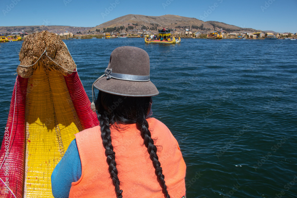 Uros woman inhabitant with typical hat and braids, driving a totora ...