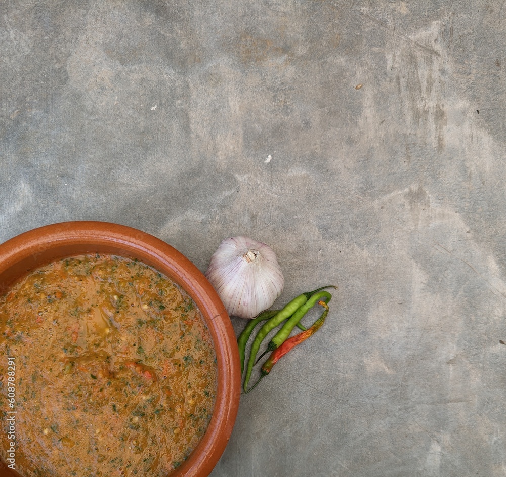 Red mexican sauce, chiles de arbol, garlic in clay recipient on corner ...