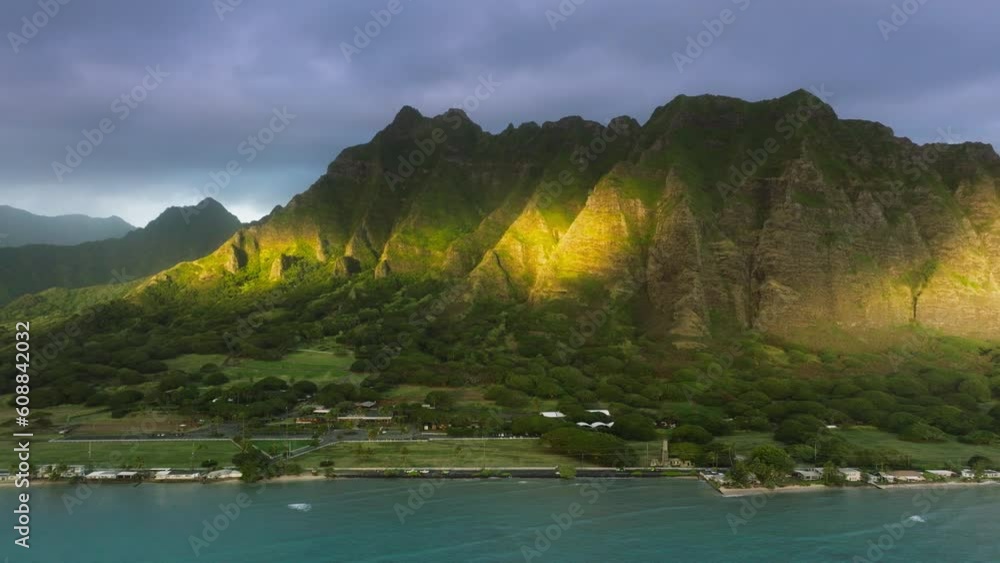 Scenic sunrise light shining at epic Kualoa Ranch mountain range ...