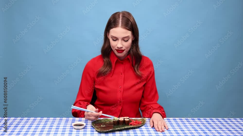 Beautiful young woman with grimacing face eating spicy sushi with ...