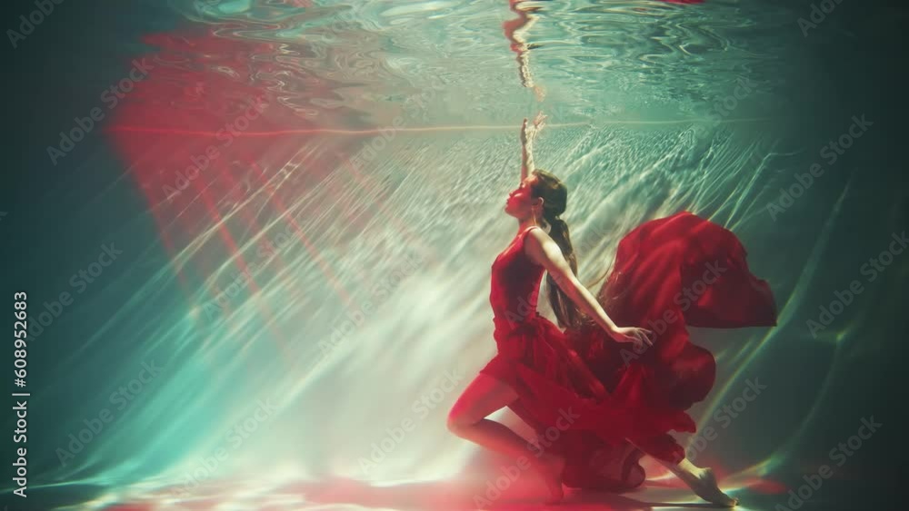 Fantasy woman swims underwater touches magic light mirror, looks into ...